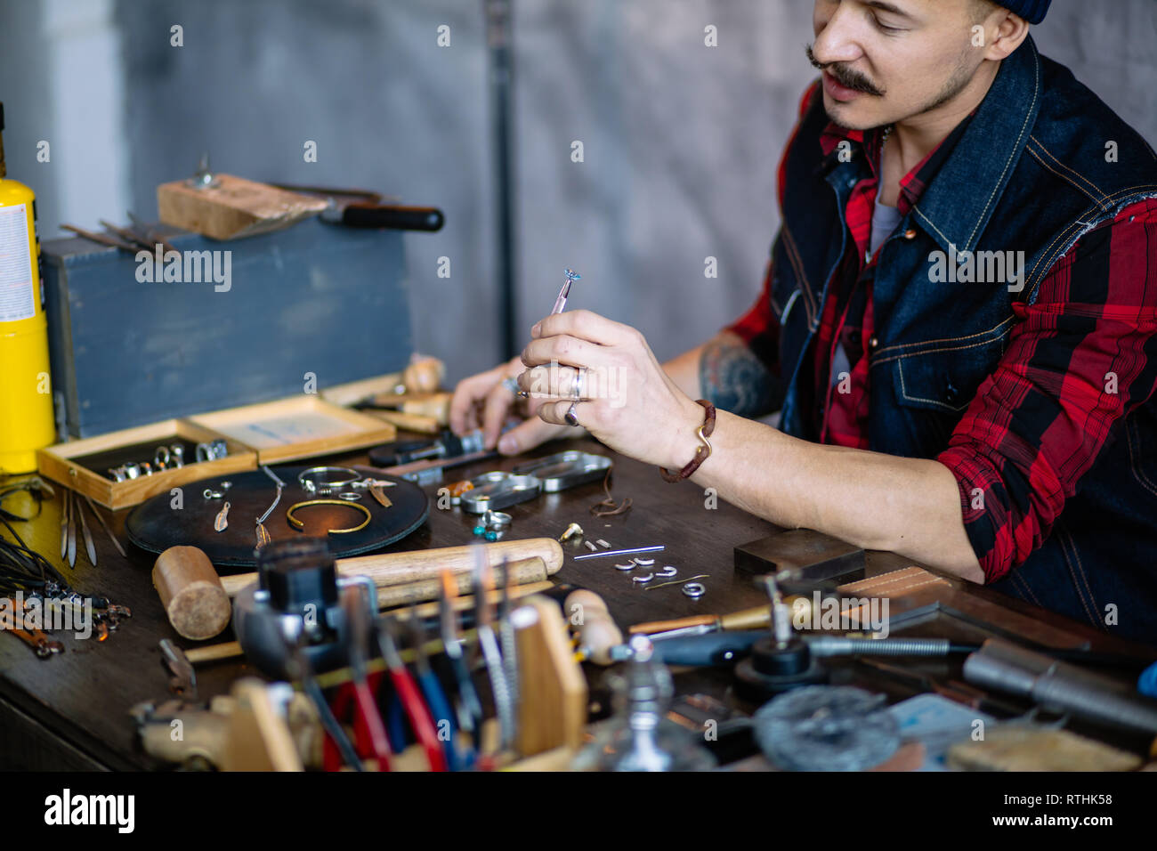 hardworking jeweler working with different pieces of metal, close up ...