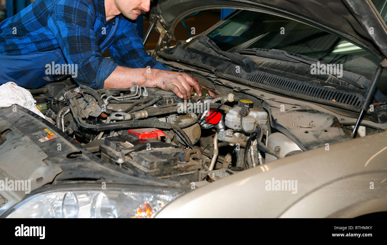 mechanic working with engine in the car service Stock Photo - Alamy