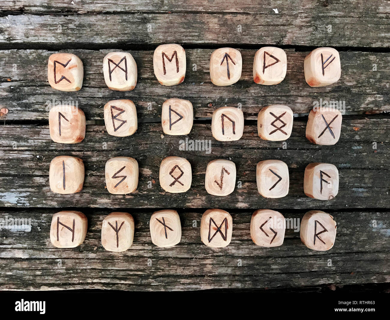 A stack of wooden runes at forest. Wooden runes lie on a old wood ...
