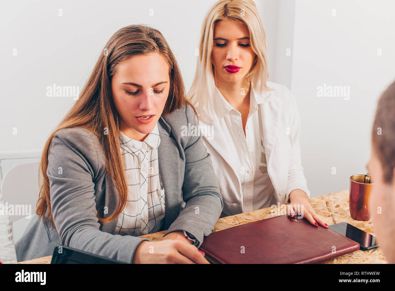 Two girl designers talking about their work plan Stock Photo - Alamy