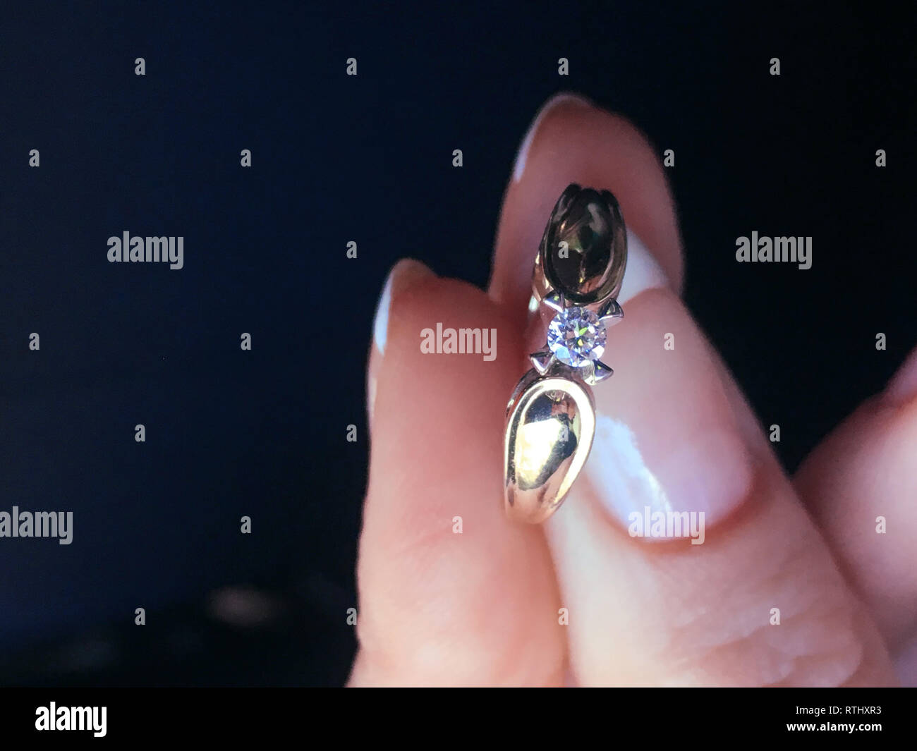 Close up of elegant diamond ring on the finger with gray Scarf ...