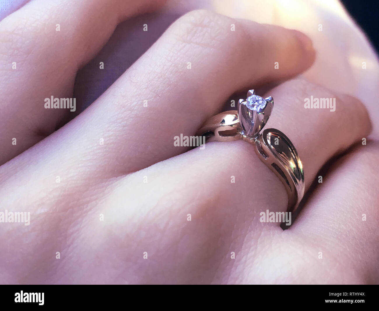 Close up of elegant diamond ring on the finger with gray Scarf ...
