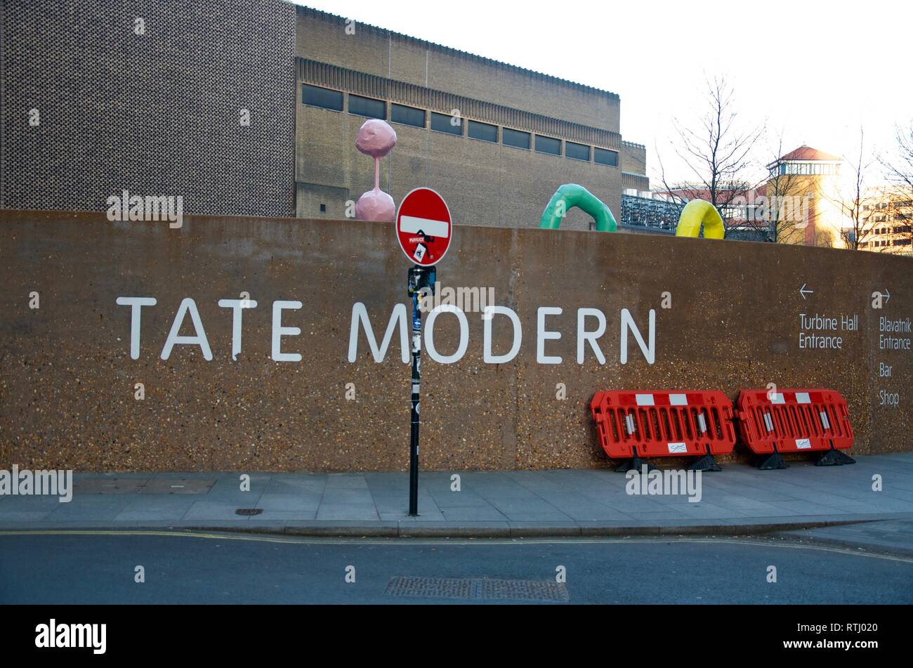 Wall outside Tate Modern gallery with colourful artworks and road signs ...