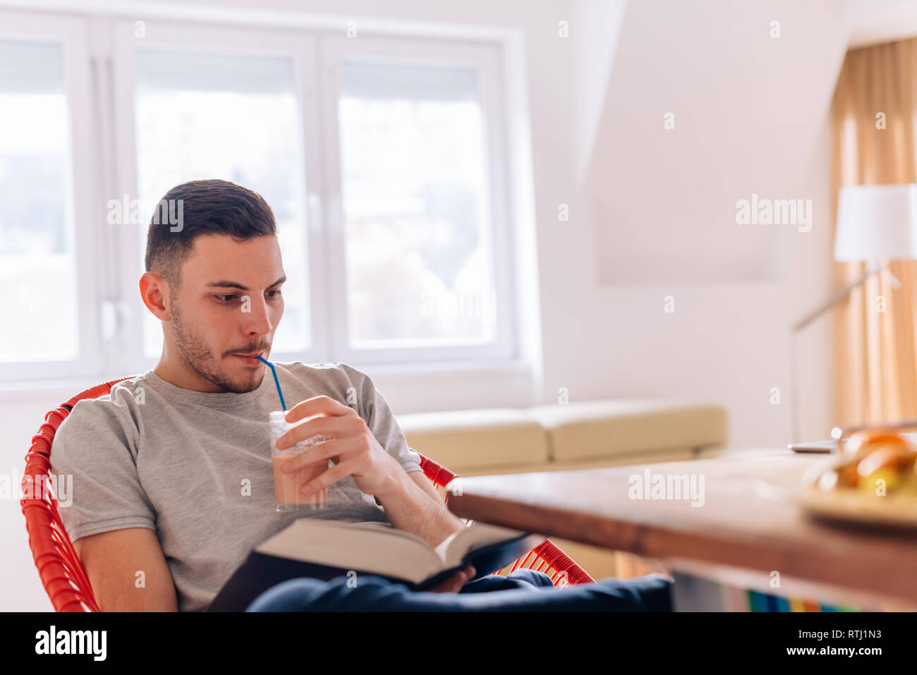 healthy strong young man reading a book early in the morning while ...