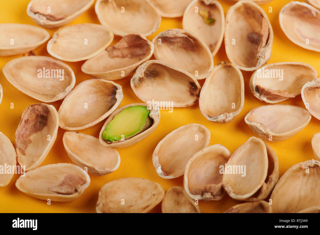 One pistachio in shell around empty cracked nutshells Stock Photo - Alamy