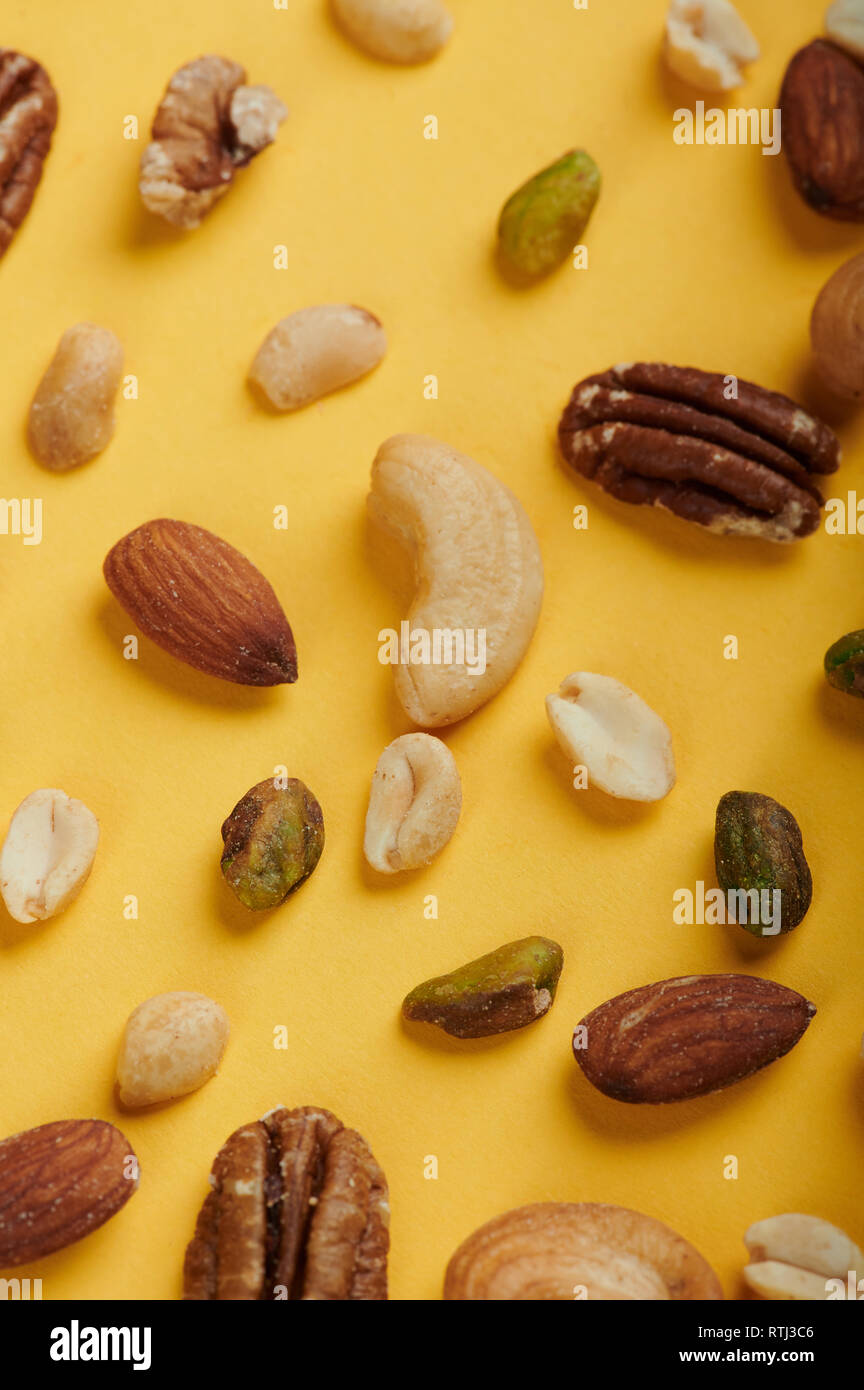 Mix of different nuts on yellow background vertical orientation Stock ...