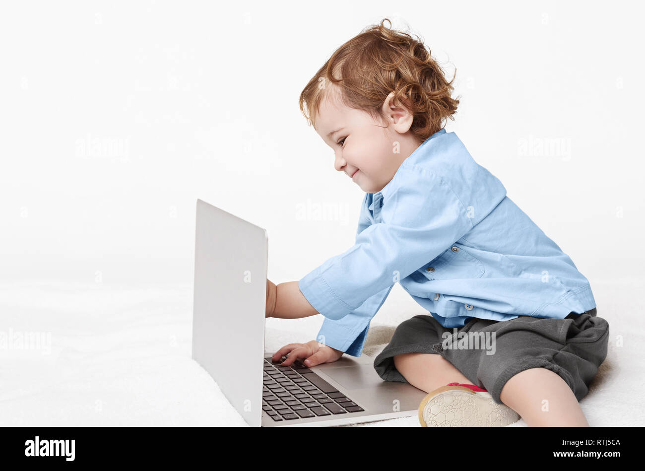 Cute baby boy talking with dad on laptop through video call, touching ...