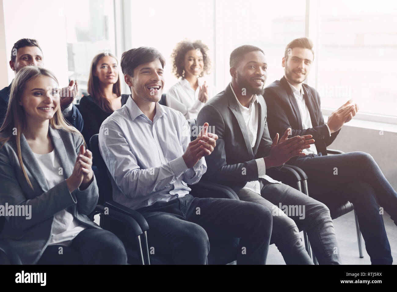 Happy business people clapping hands at conference Stock Photo - Alamy