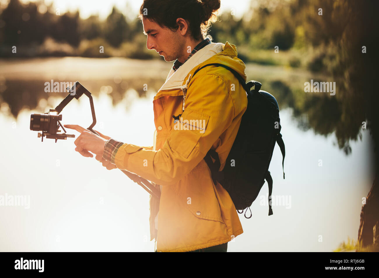 Side view of a traveler taking photos on a hand held camera stabilizer ...