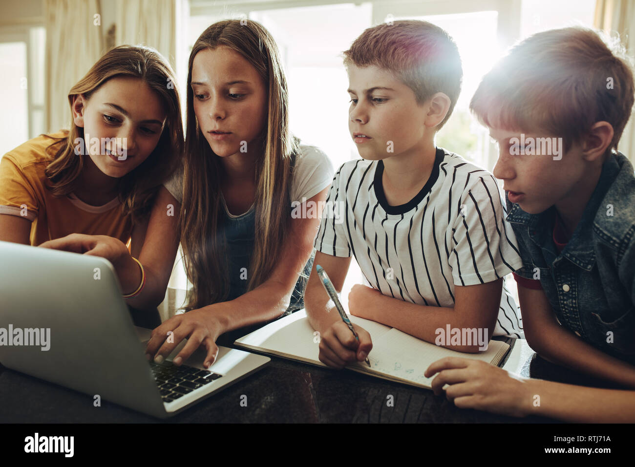 Group of kids learning together on a laptop computer. Young girl ...