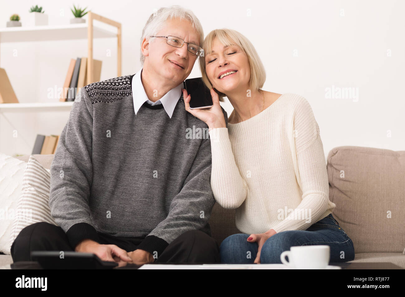Senior couple sharing smartphone, having phone call Stock Photo - Alamy