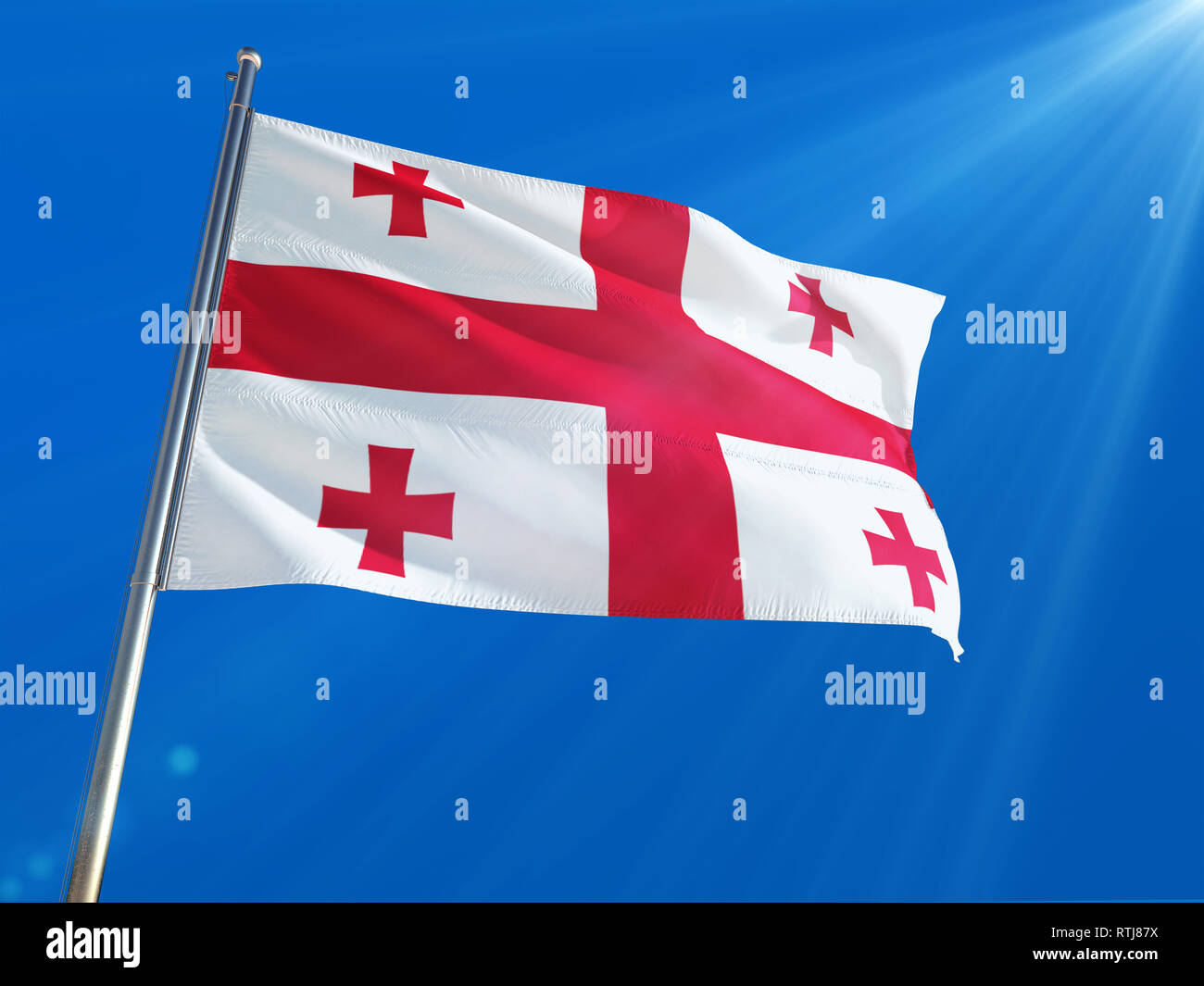 Georgia National Flag Waving on pole against deep blue sky background ...