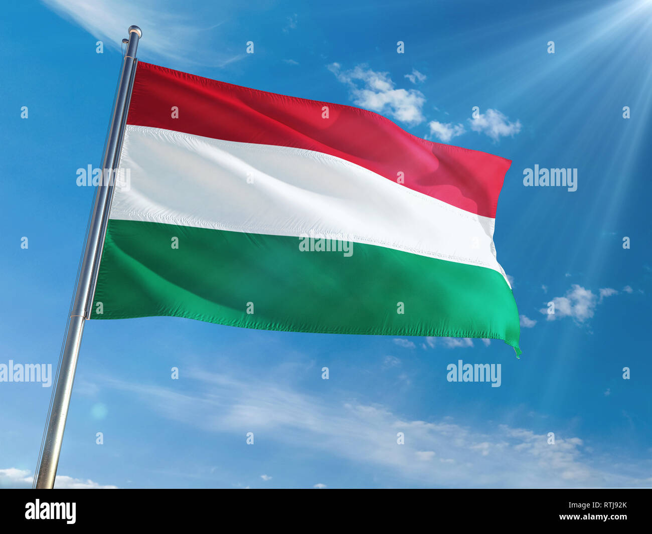 Hungary National Flag Waving on pole against sunny blue sky background ...