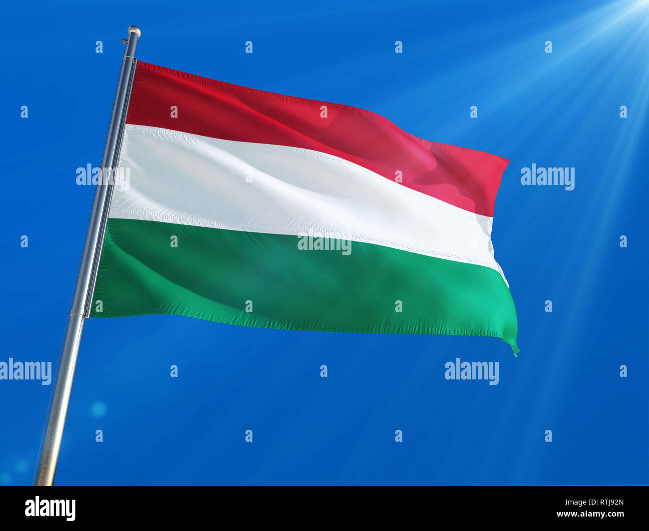 Hungary National Flag Waving on pole against deep blue sky background ...