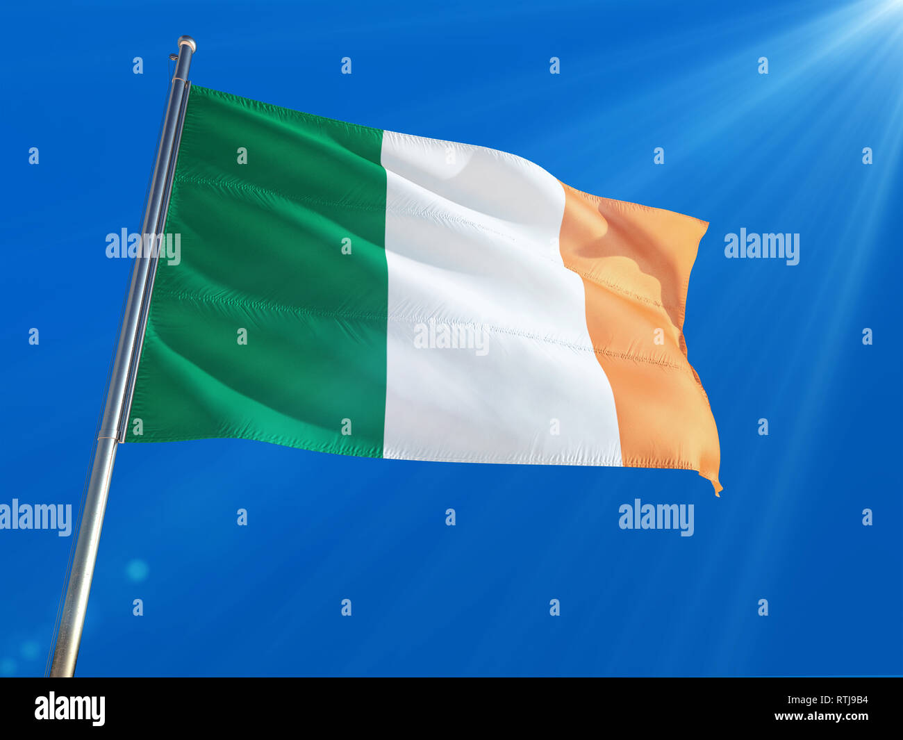 Ireland National Flag Waving on pole against deep blue sky background ...