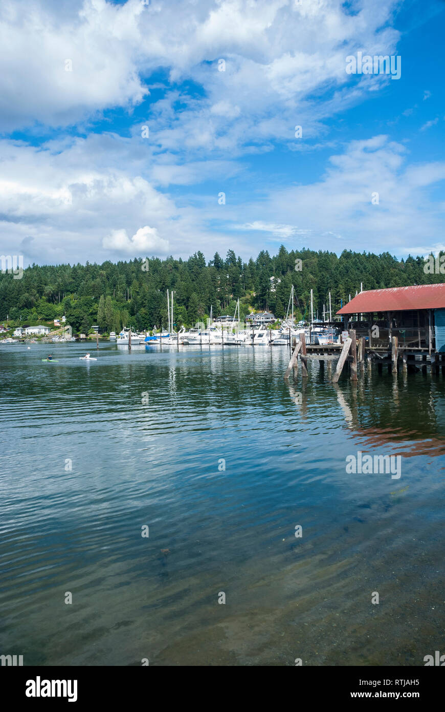 Kayak paddlers and a boat shed in Gig Harbor, Washington Stock Photo ...
