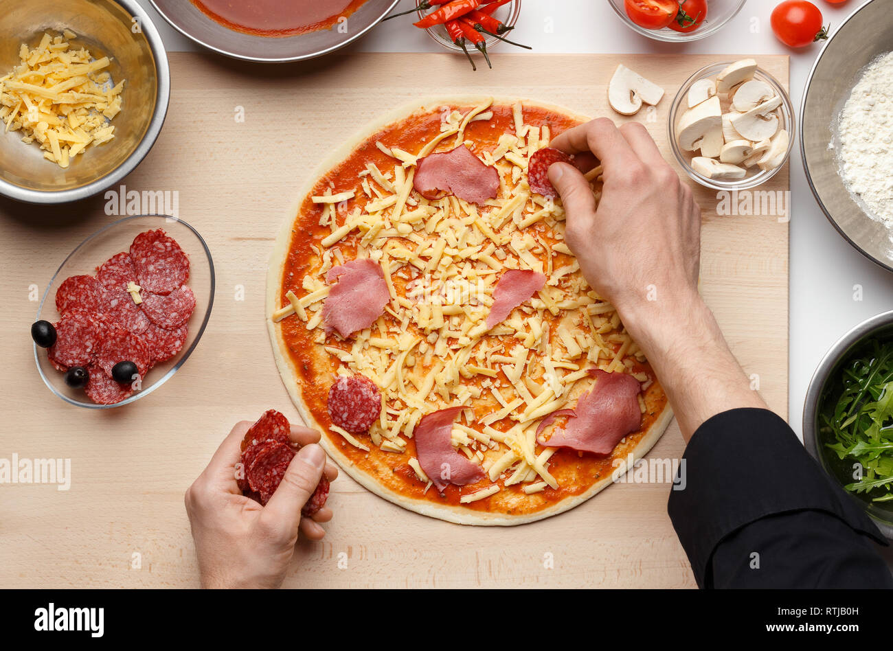 Chef decorating pizza with salami in restaurant Stock Photo - Alamy