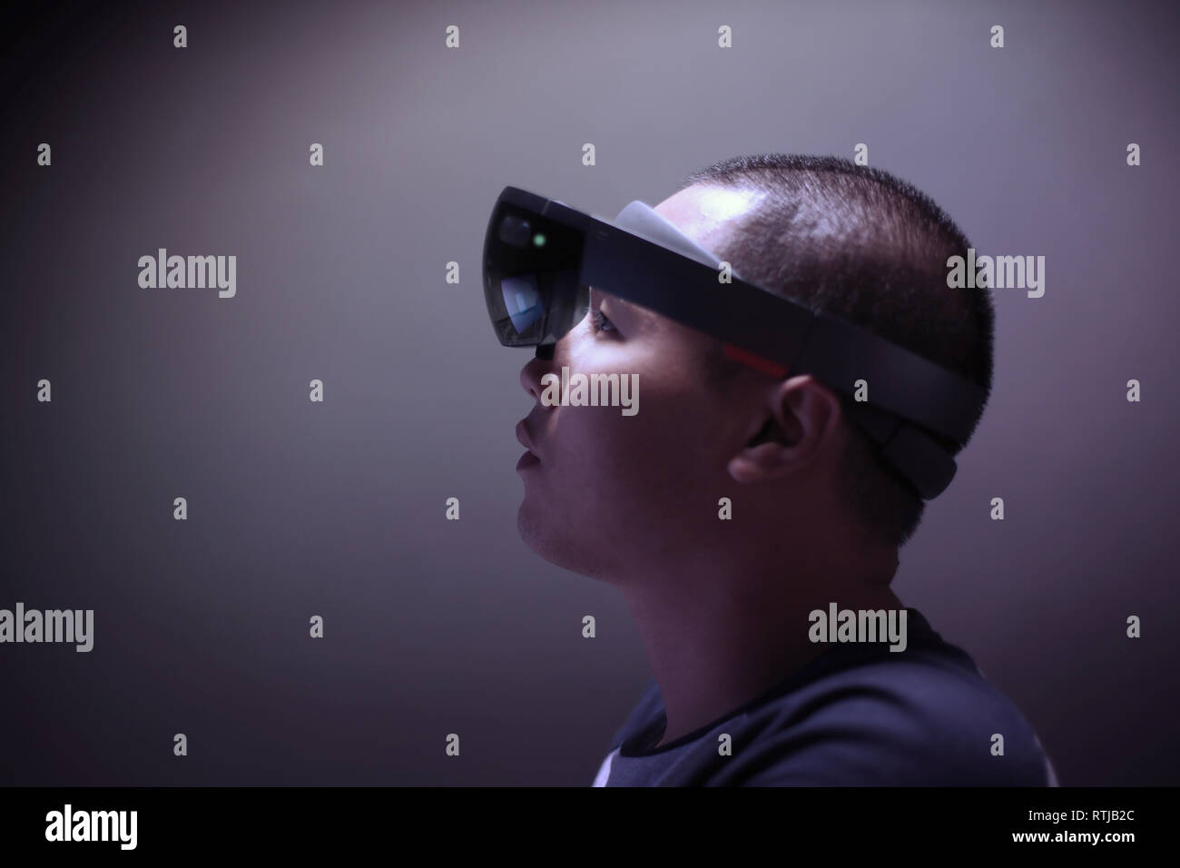 Portrait of young man with 3D virtual reality eye wear glasses hololens ...