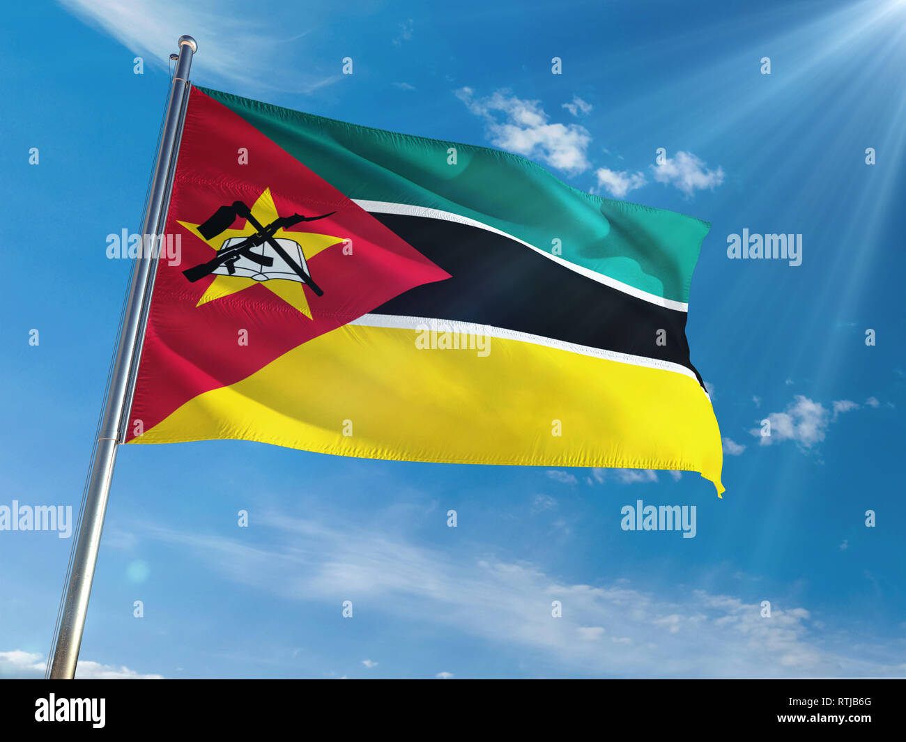 Mozambique National Flag Waving on pole against sunny blue sky ...
