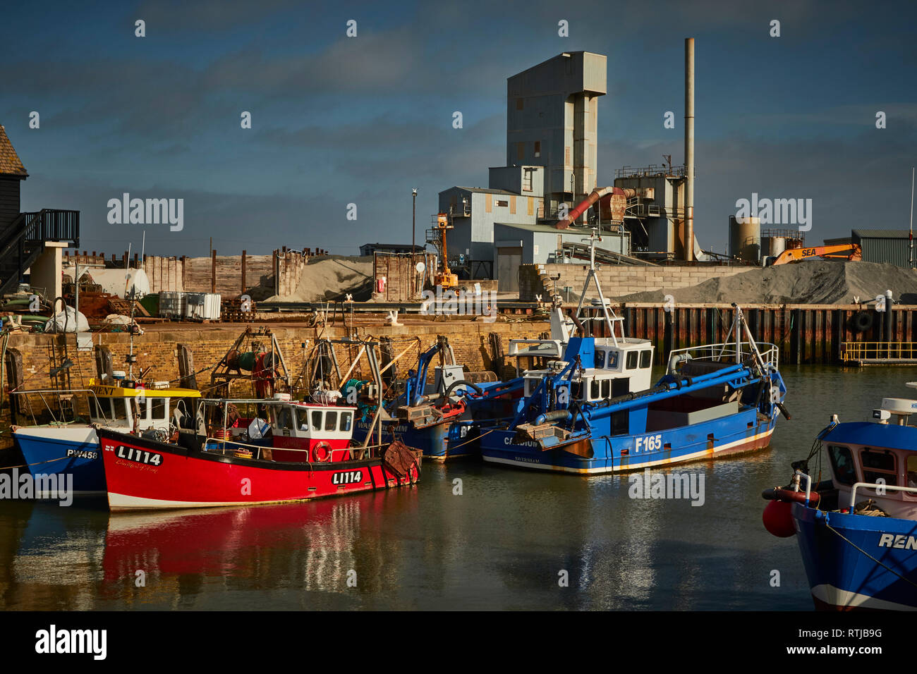 Boats in Whitstable harbour with Brett aggregates factory in the ...