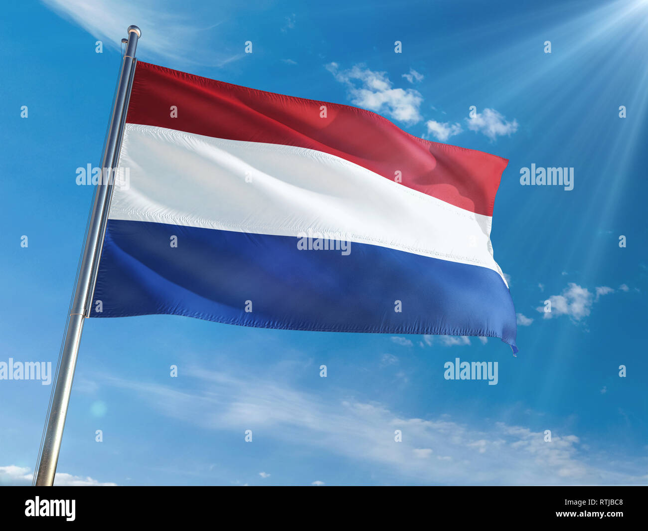 Netherlands National Flag Waving on pole against sunny blue sky ...