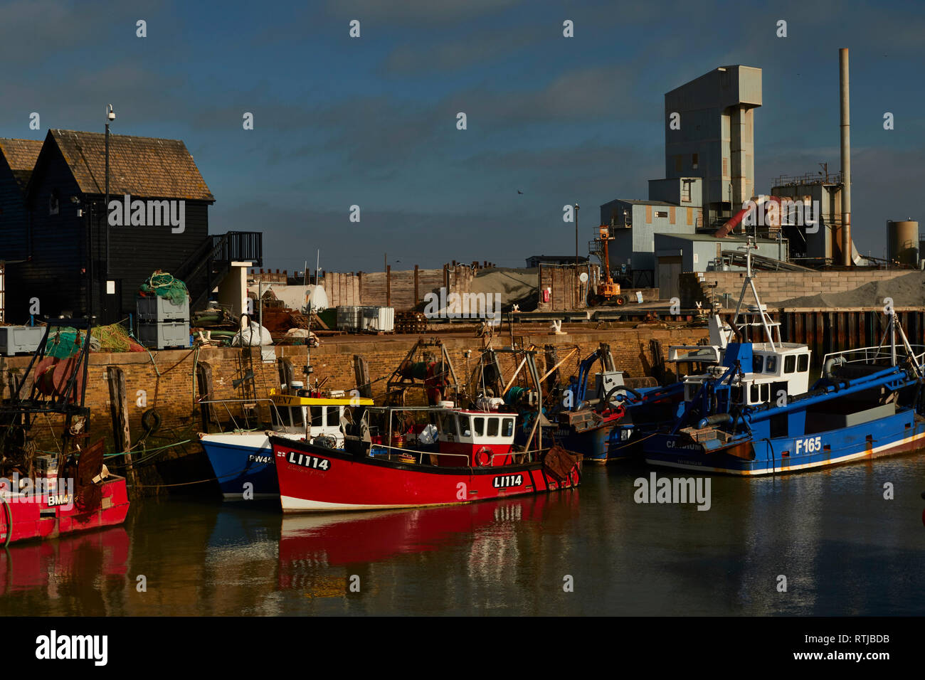Boats in Whitstable harbour with Brett aggregates factory in the ...