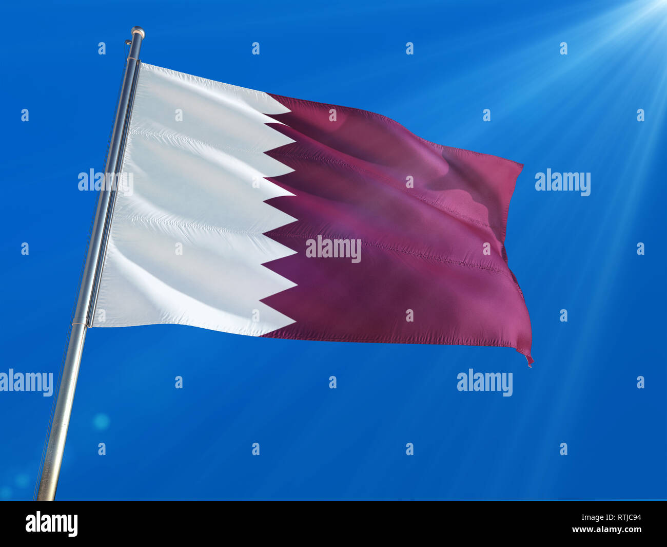 Qatar National Flag Waving on pole against deep blue sky background ...