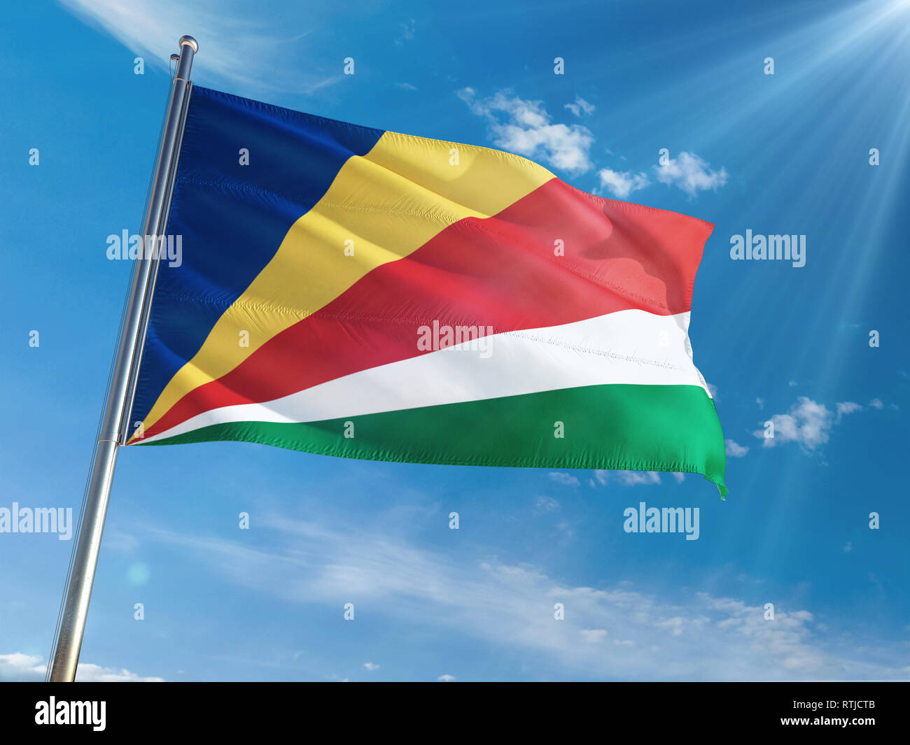 Seychelles National Flag Waving on pole against sunny blue sky ...