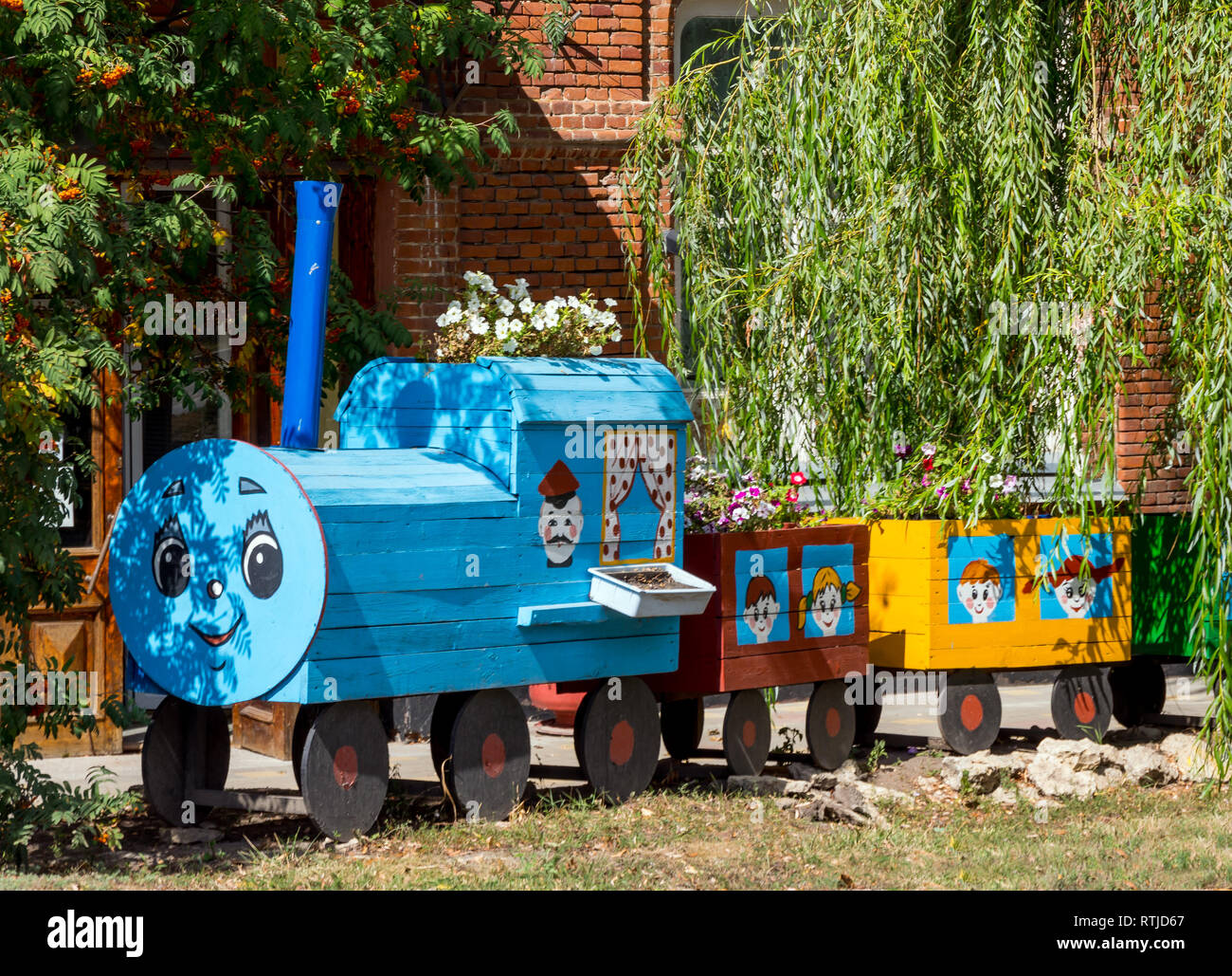 Flowerbed made in the form of a wooden steam locomotive with wagons ...