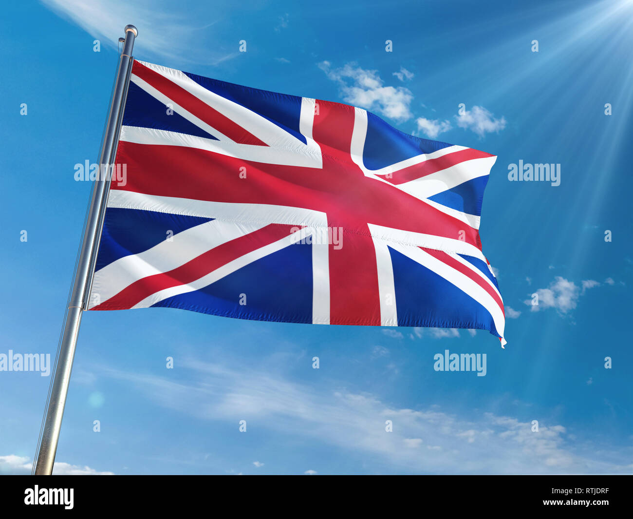 United Kingdom National Flag Waving on pole against sunny blue sky ...
