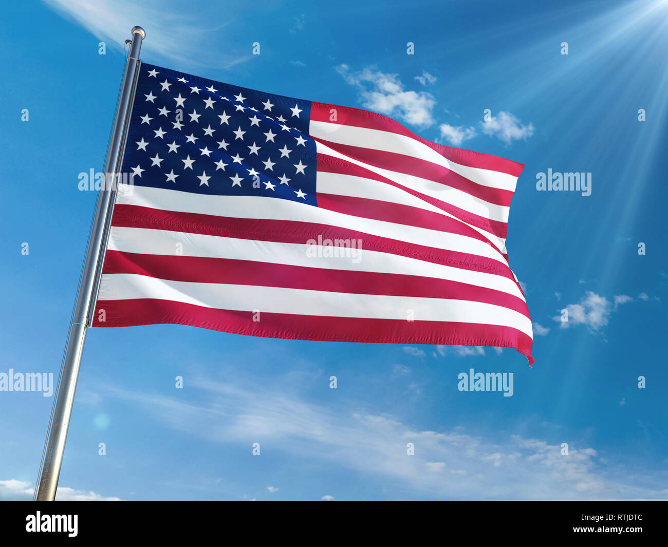 United States National Flag Waving on pole against sunny blue sky ...