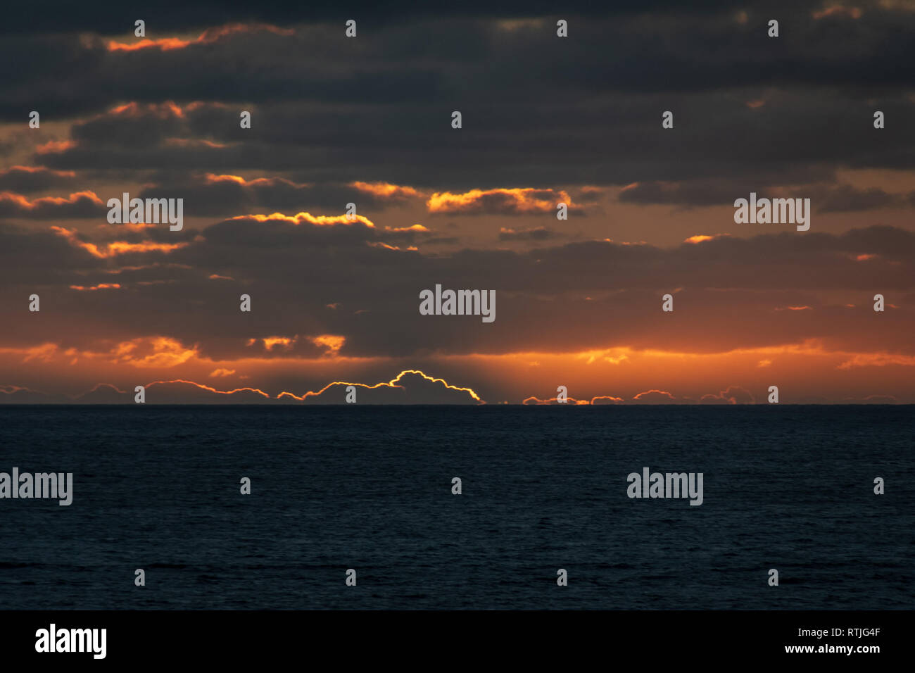 Sun already set behind the horizon giving the clouds an orange ...