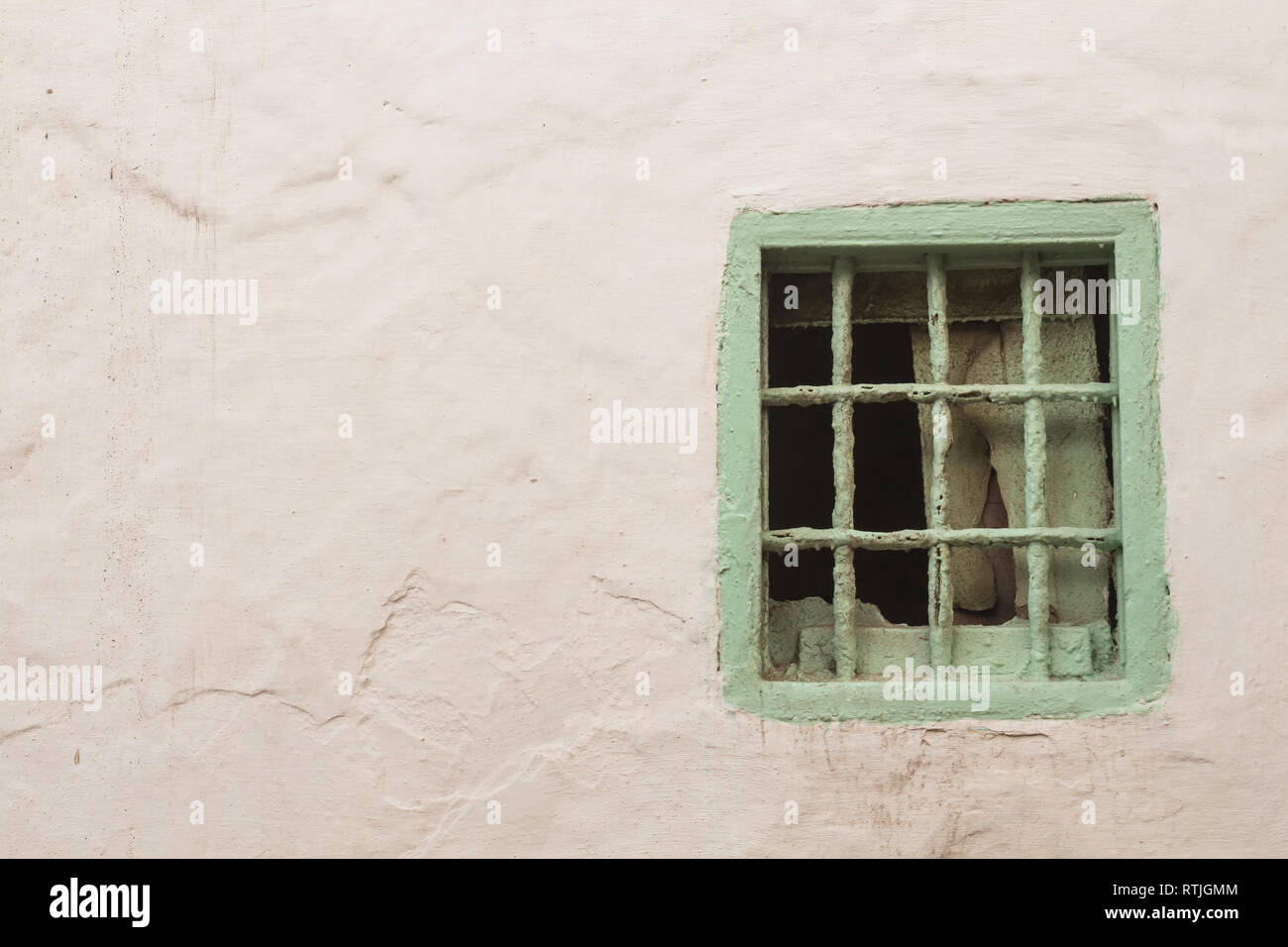 White facade of a house with a small light green frame and grating of a ...