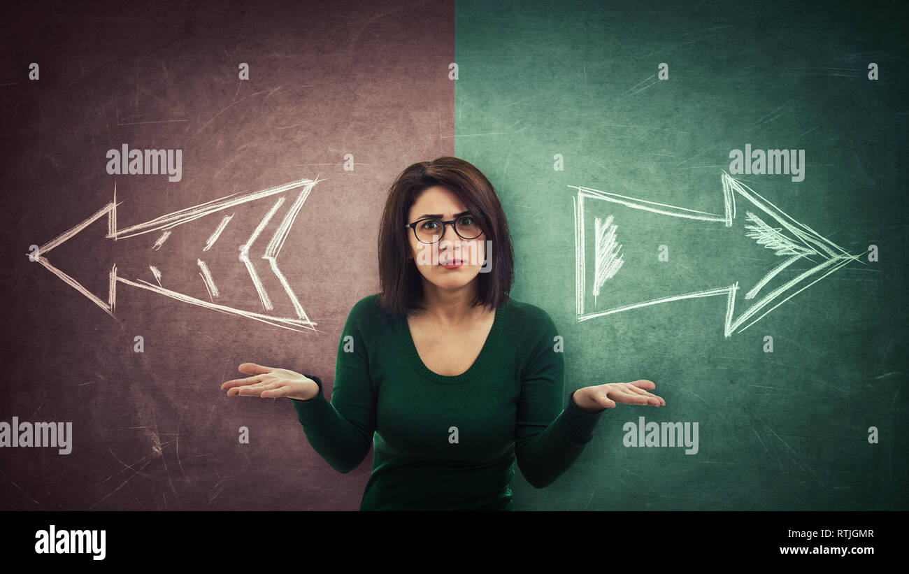 Perplexed businesswoman has to choose. Split blackboard and arrows ...