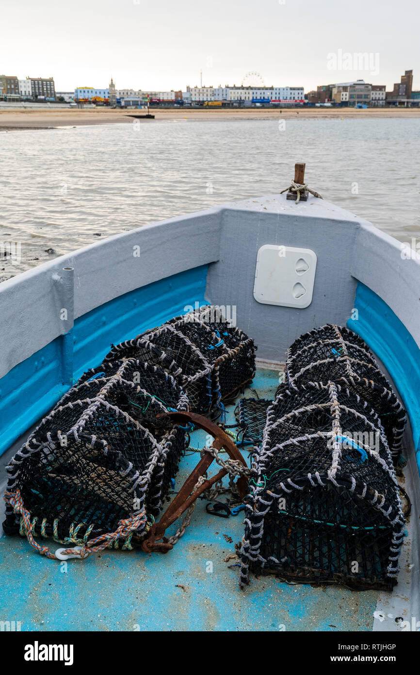 Two rows of lobster pots, traps, with rusty anchor between them, in the ...