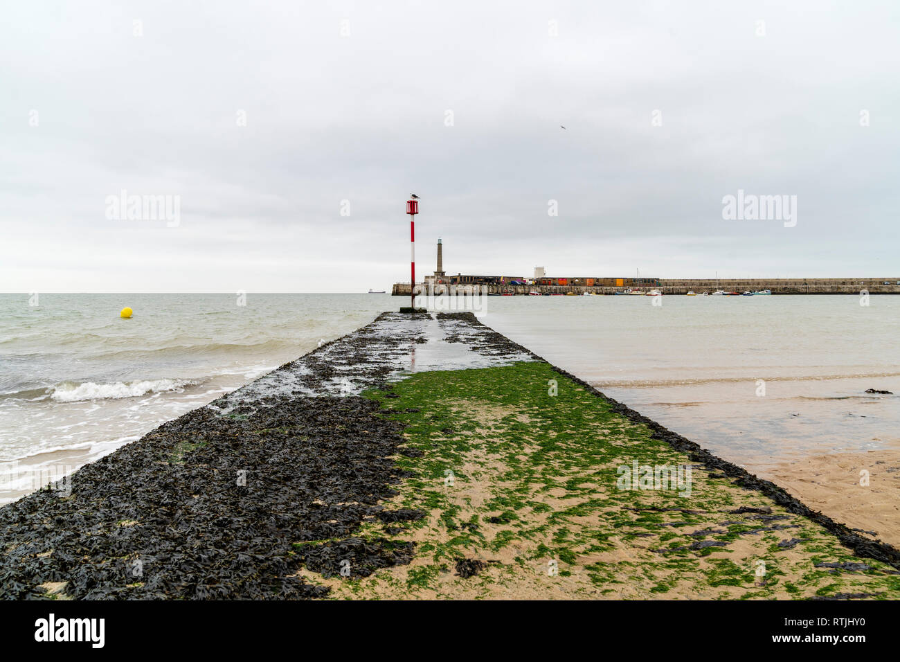 Margate seafront. Seaweed covered concrete wave breaker with navigation ...