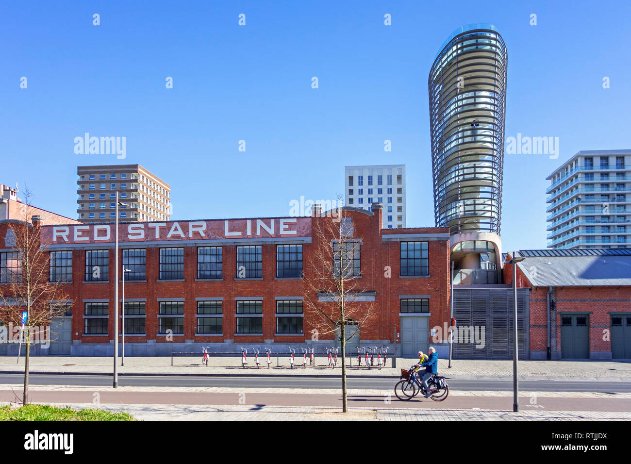 Two cyclists riding past the Red Star Line museum in the city Antwerp ...