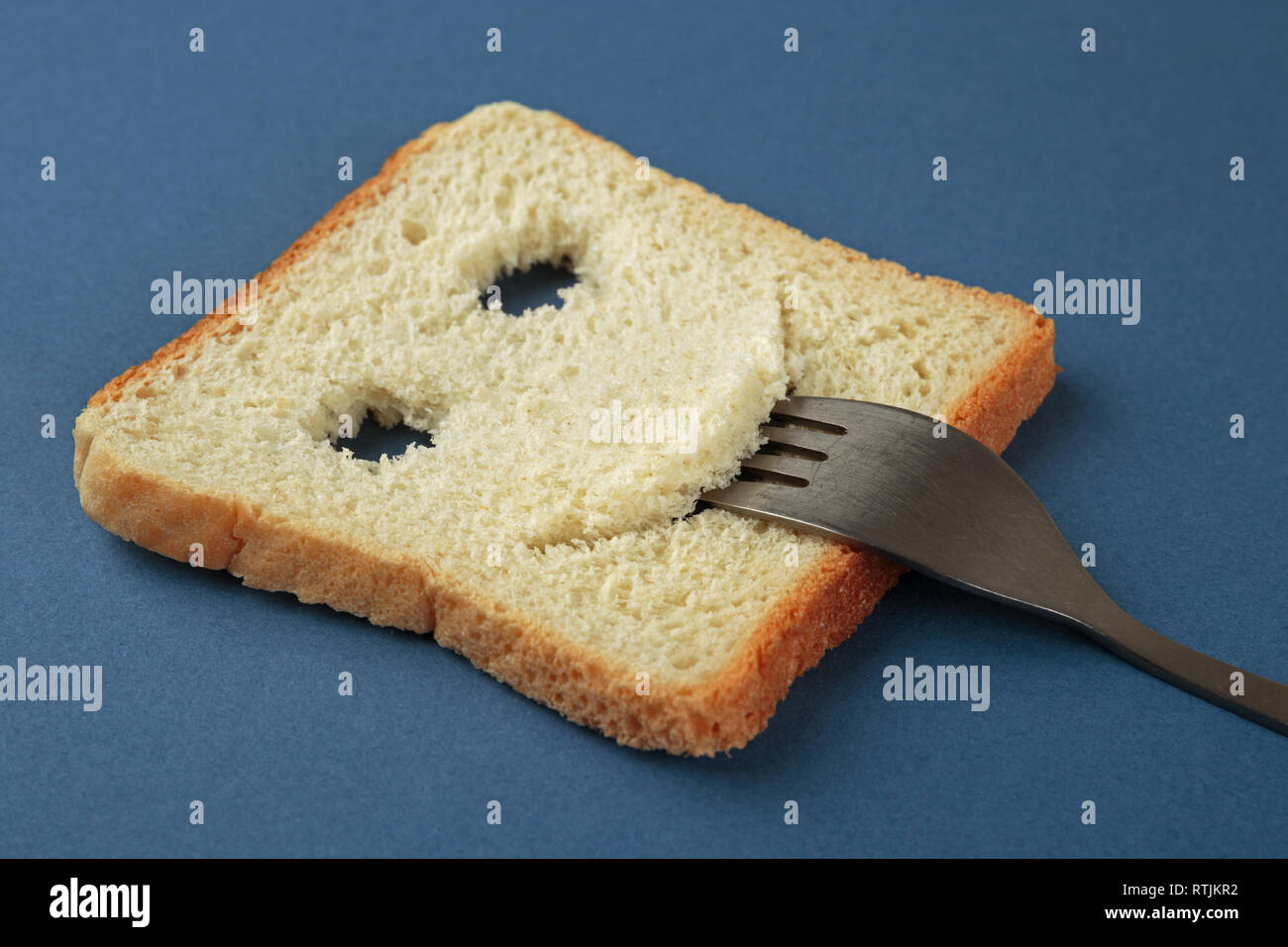 Happy toast with a fork in her mouth on a blue cutting board Stock ...