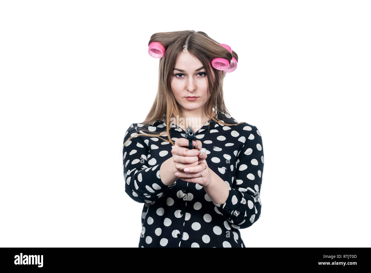 beautiful business woman in curlers aiming a gun at the camera isolated ...