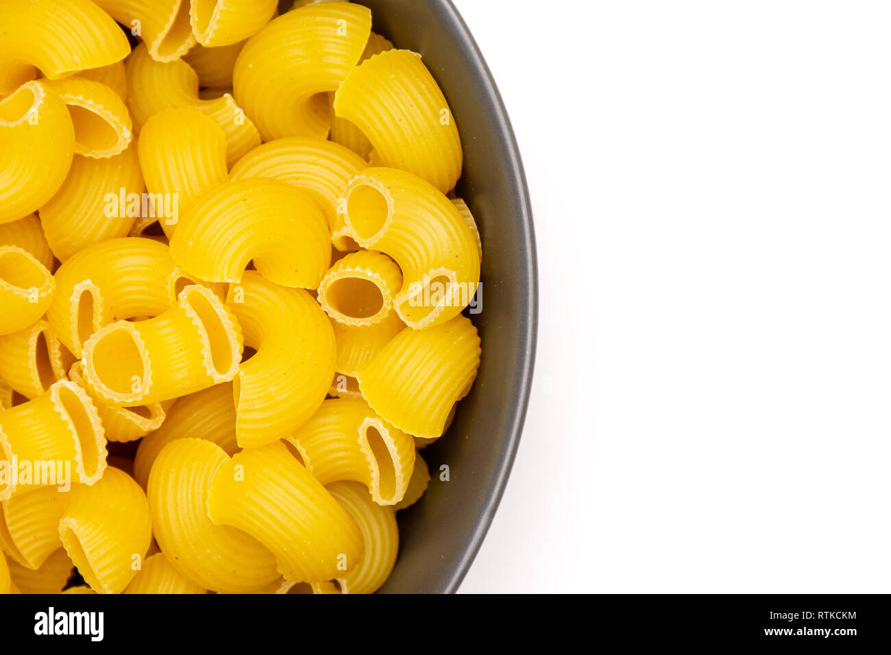 Lot of whole raw pasta pipe rigate variety in a grey ceramic bowl ...