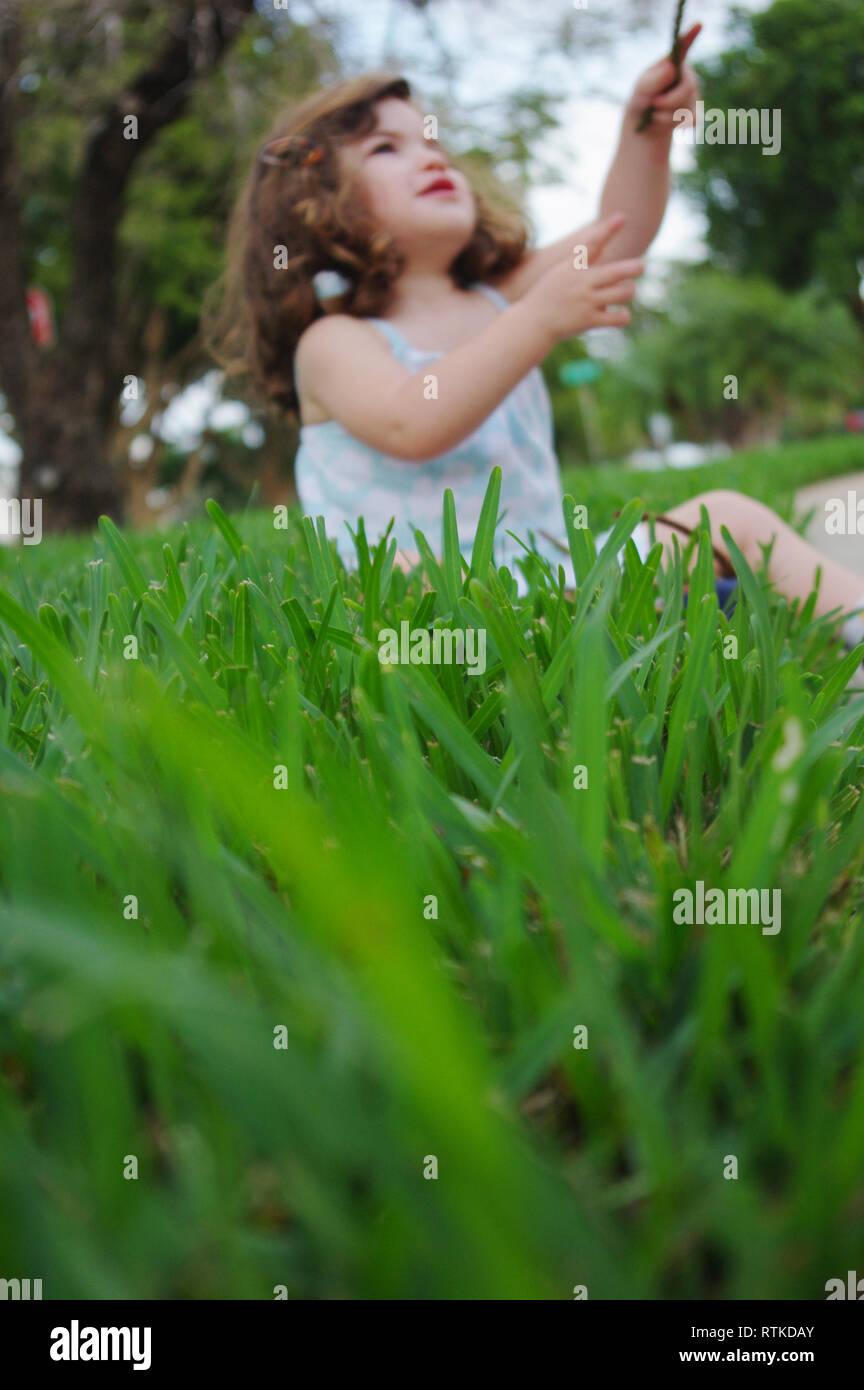 Toddler girl playing in grass Stock Photo - Alamy