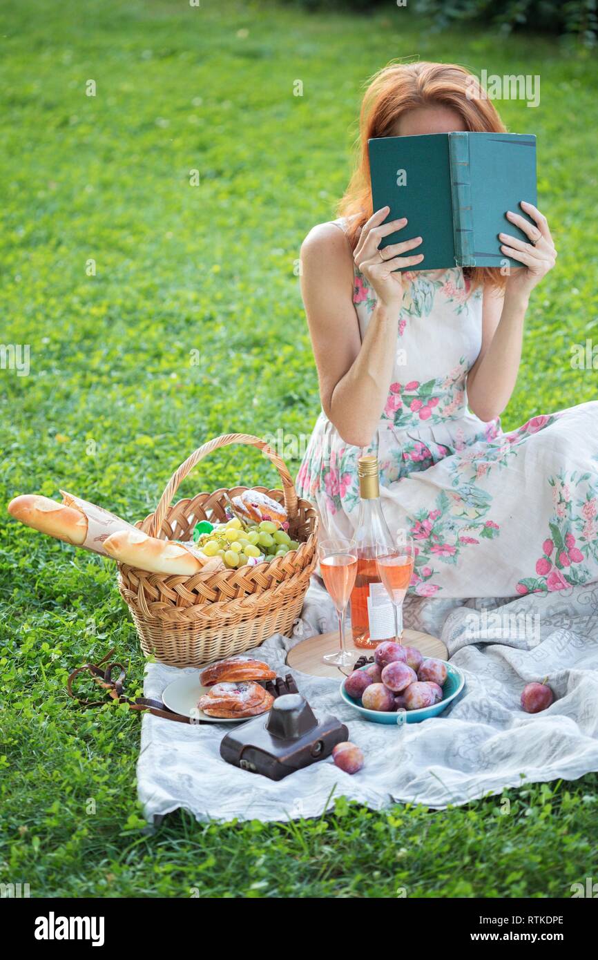 Summer - picnic in the meadow. girl sitting reading a book and near a ...