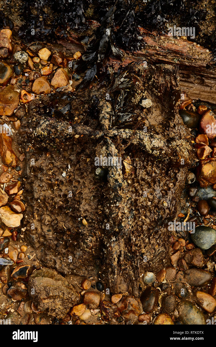 Rusted metal cross at low tide on the Kent coast, England, United ...