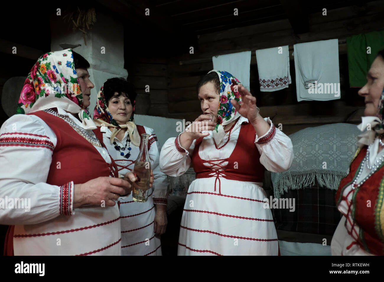 Belarusian women in traditional garment drink homemade Samogon ...