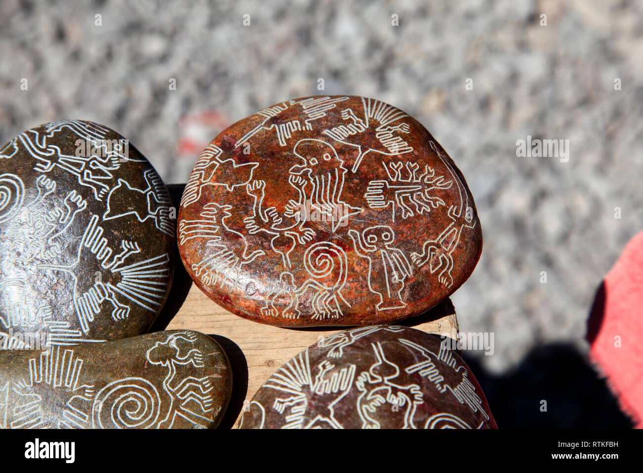 Souvenirs of Nazca lines carved into small rounded stones Stock Photo ...