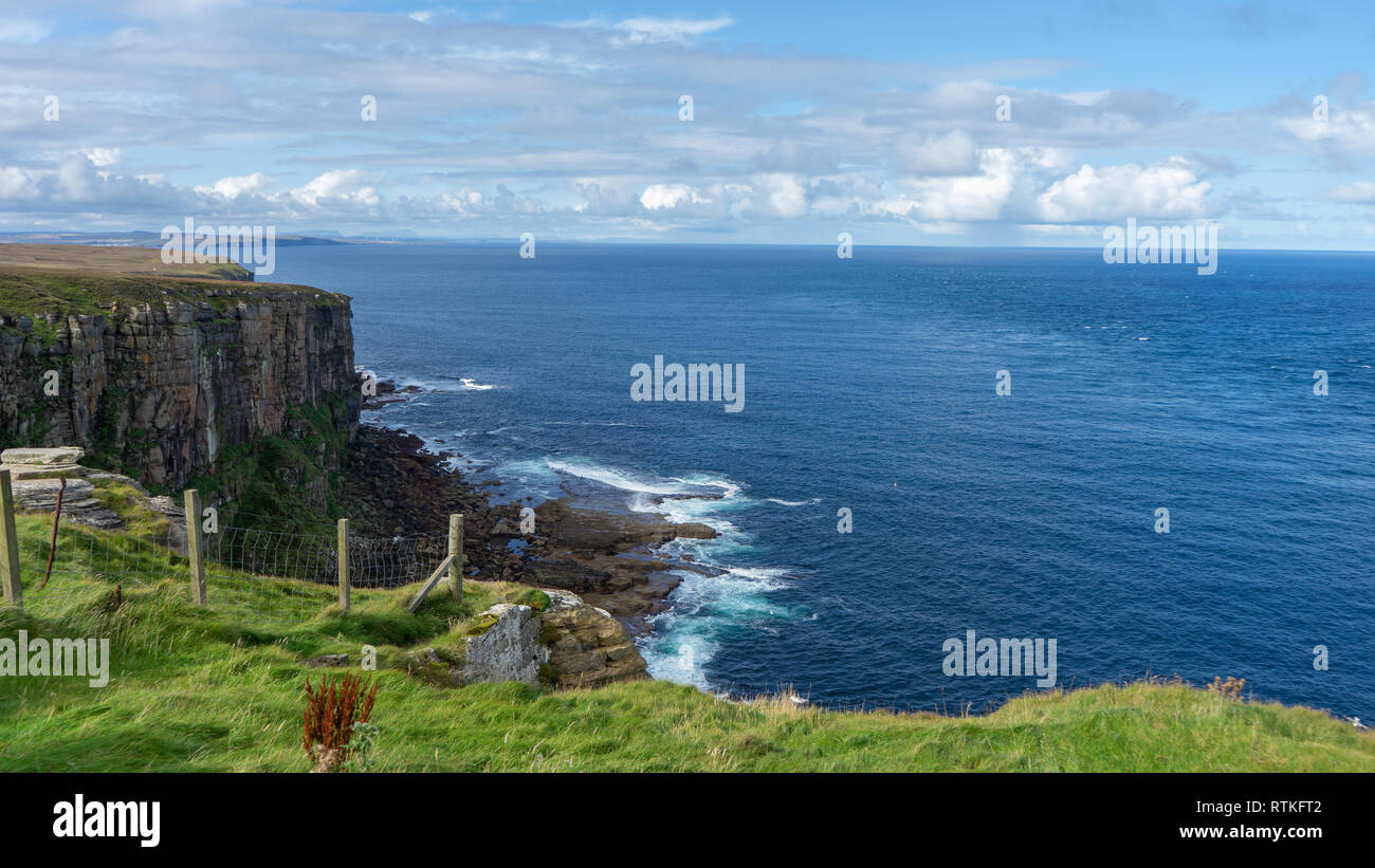 Scottish coast with view on Orkney islands and lighthouse Stock Photo ...