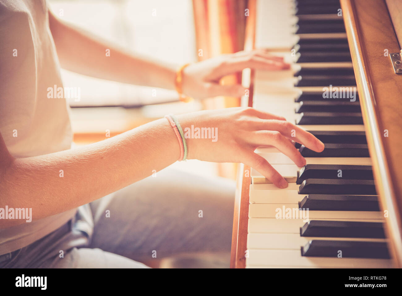 Young girl is practicing piano at home. Clipping of piano and hands ...
