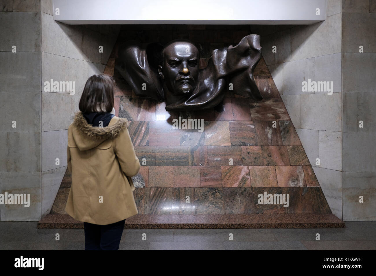 A young Belarusian woman lookinf at the statue of Vladimir Lenin placed ...