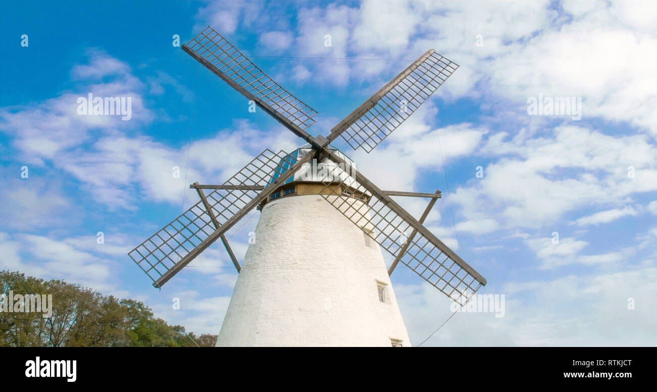 The old windmill with four blades in the farm. It is a big white ...