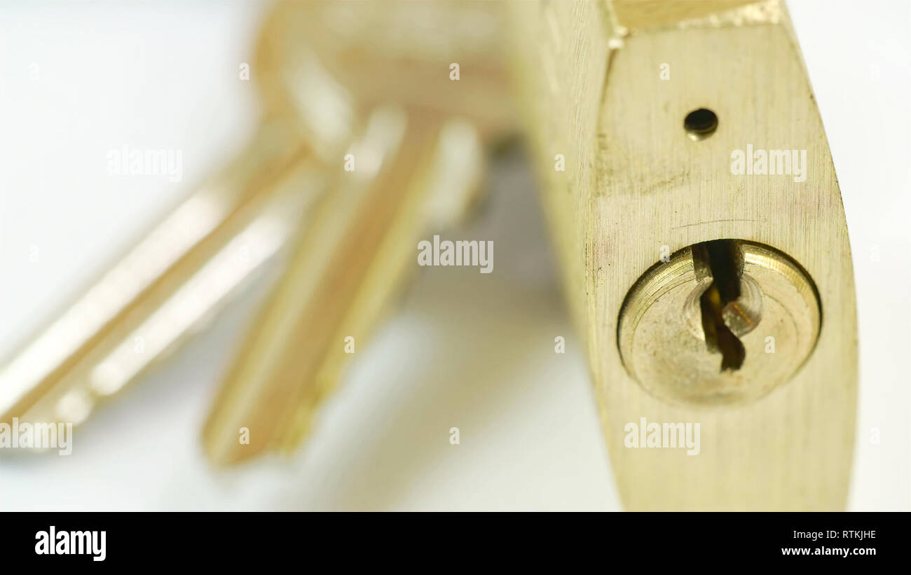 A padlock and the keys. It is golden brown in color used to lock gates ...